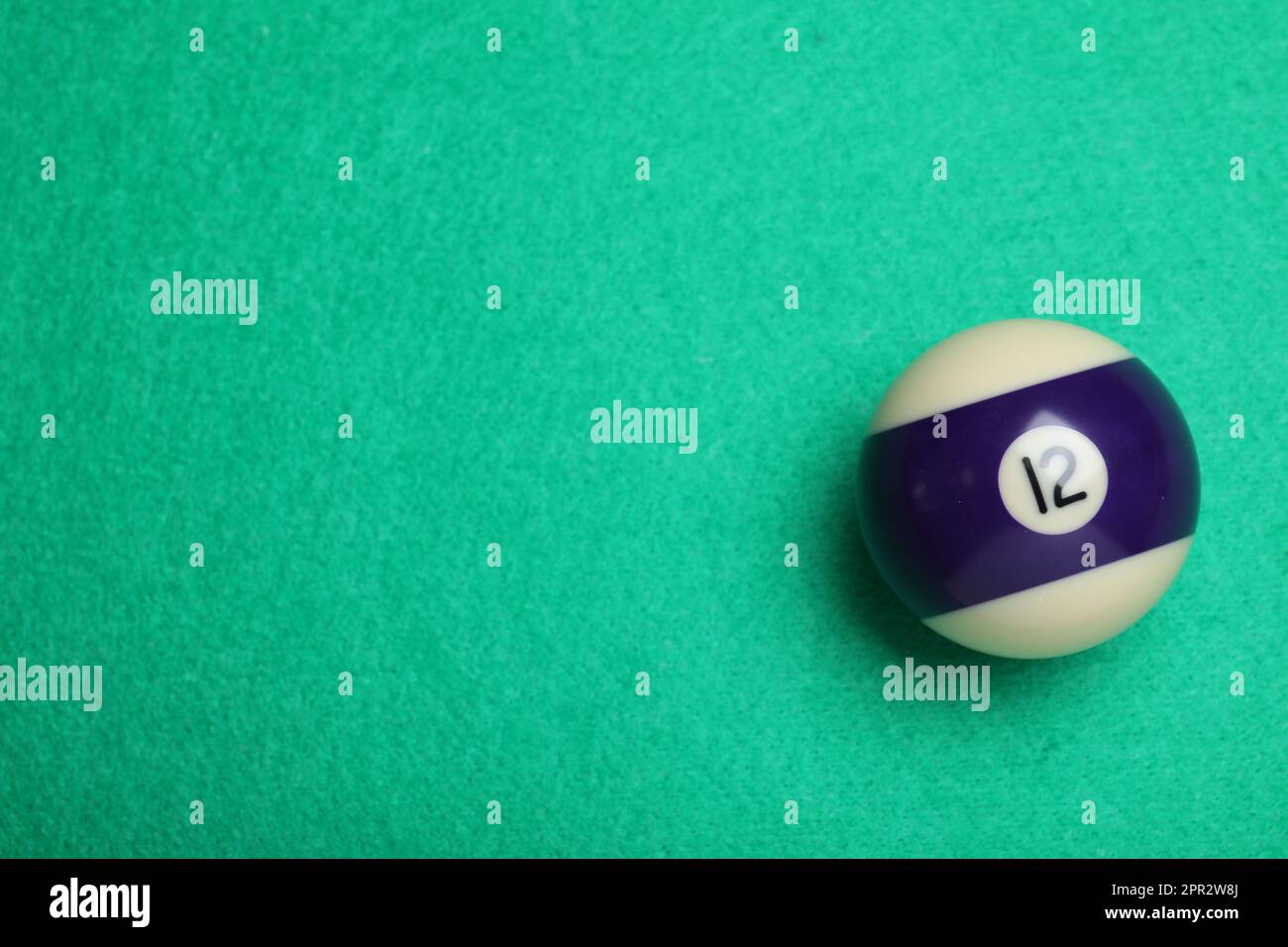 Billiard ball with number 12 on green table, top view. Space for text ...