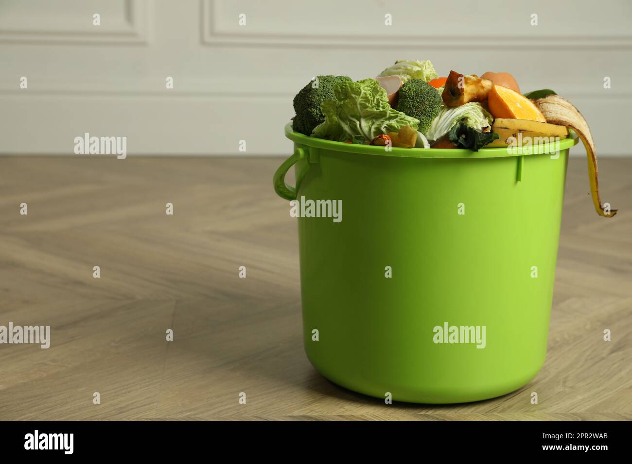 Trash bin with natural garbage indoors, space for text. Composting of ...