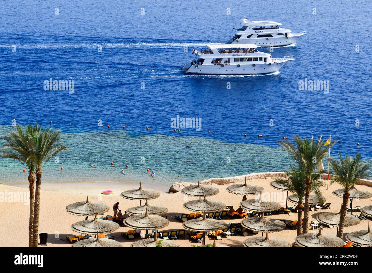 Top view of a sandy beach with sunbeds and sun umbrellas and two large ...