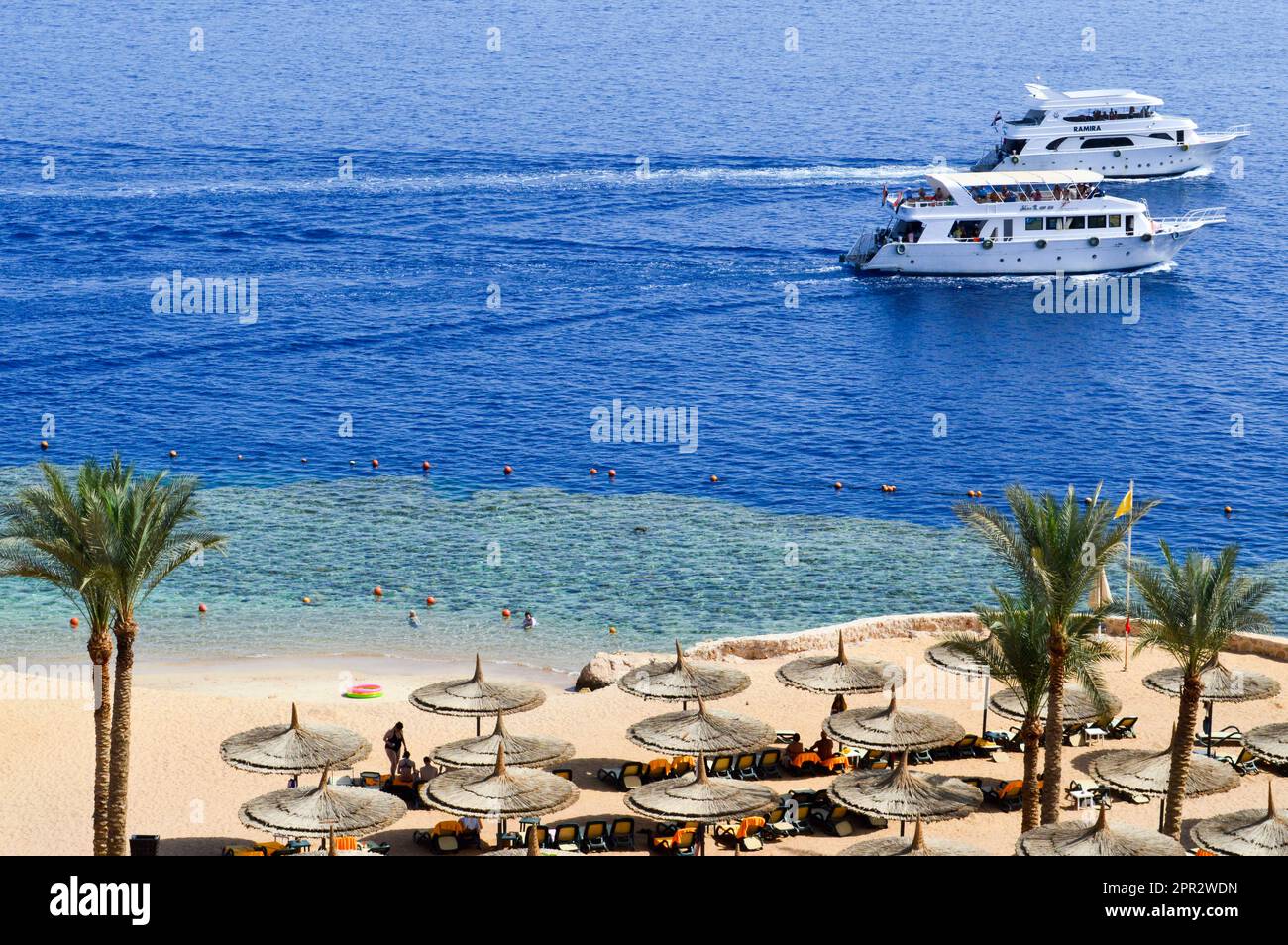 Top view of a sandy beach with sunbeds and sun umbrellas and two large ...
