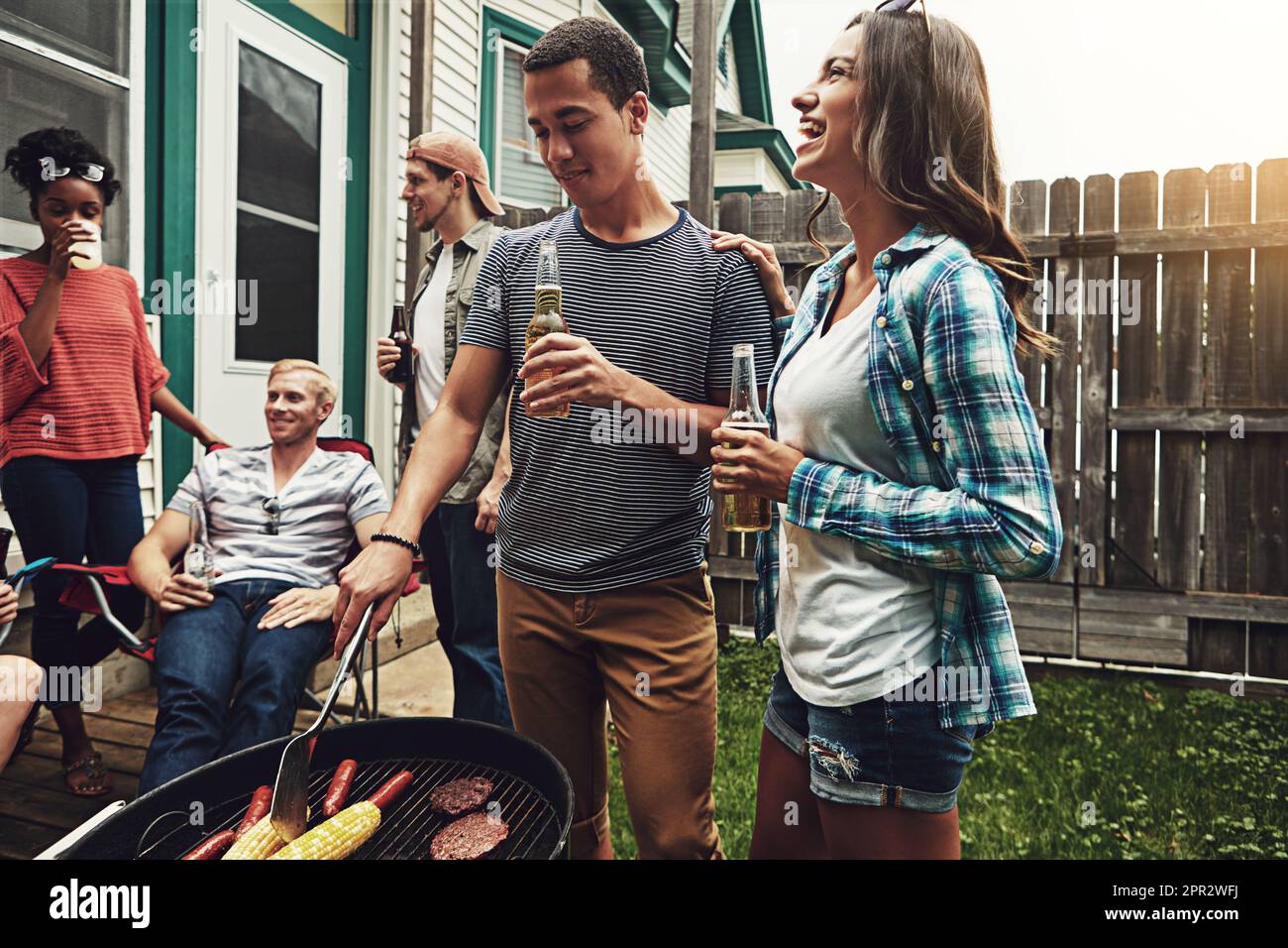 Summer time is cookout time. a group of friends having a barbecue in ...