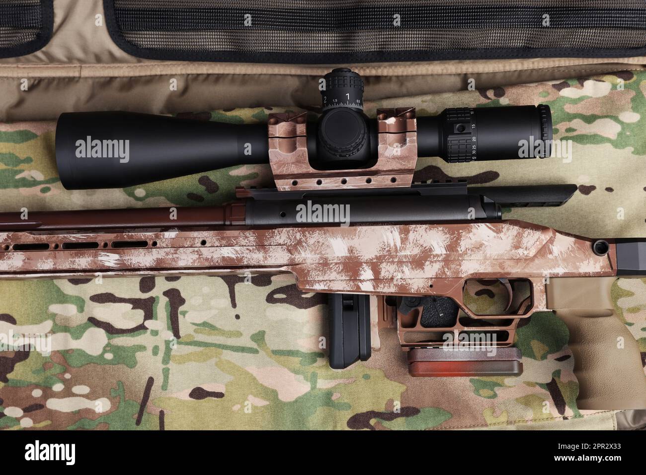 Modern powerful sniper rifle with telescopic sight on camouflage fabric ...