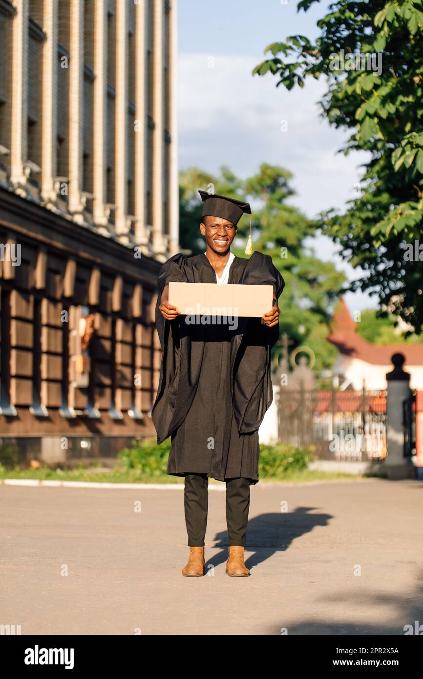 Young unemployed black guy standing with empty cardboard poster on ...