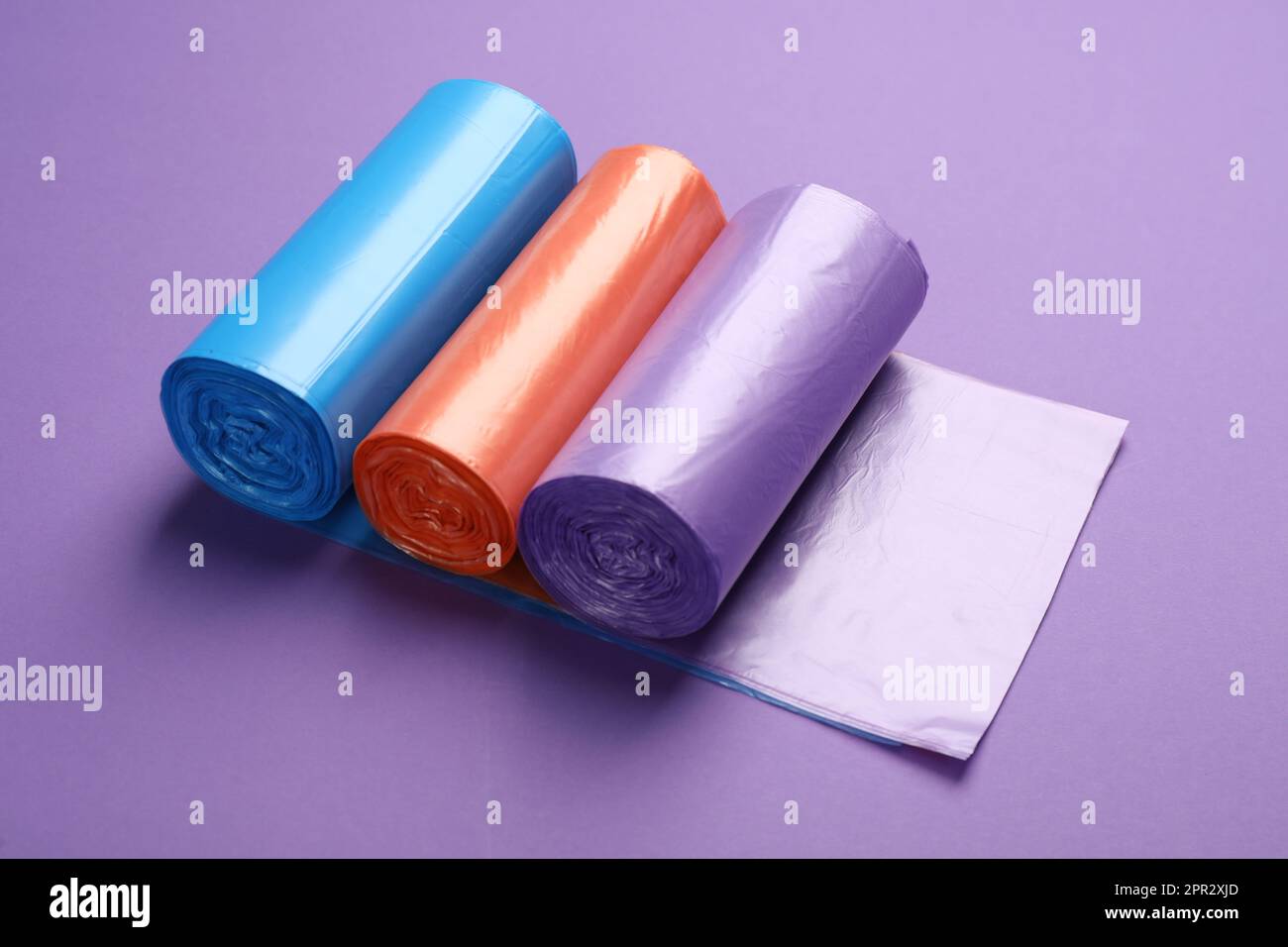 Rolls of different color garbage bags on violet background Stock Photo ...