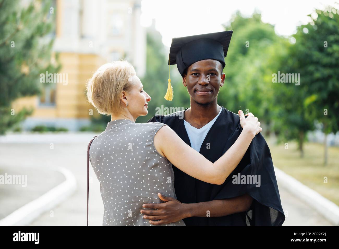 Happy afro american student in graduation mantle and hat thankfully ...