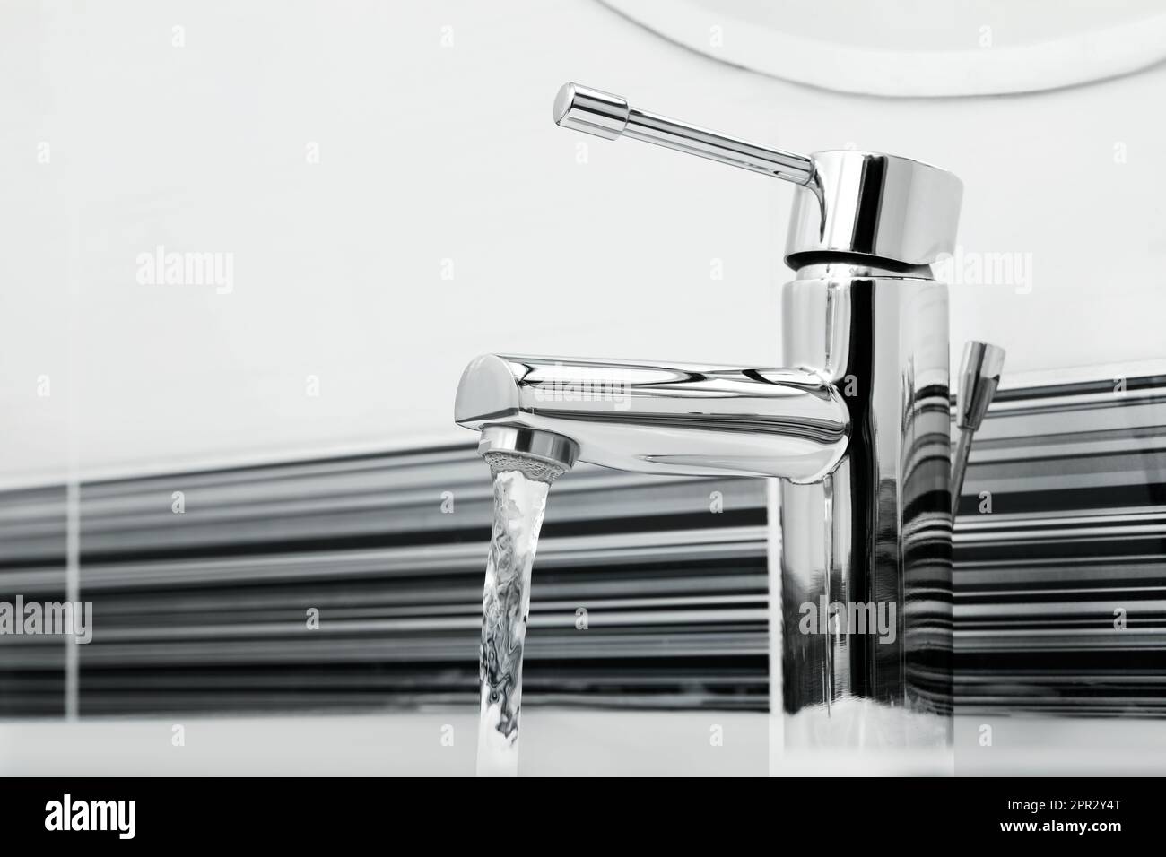 Stream of water flowing from tap in bathroom Stock Photo - Alamy
