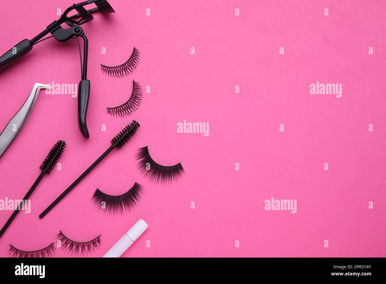 Flat lay composition with fake eyelashes, brushes and tools on pink ...