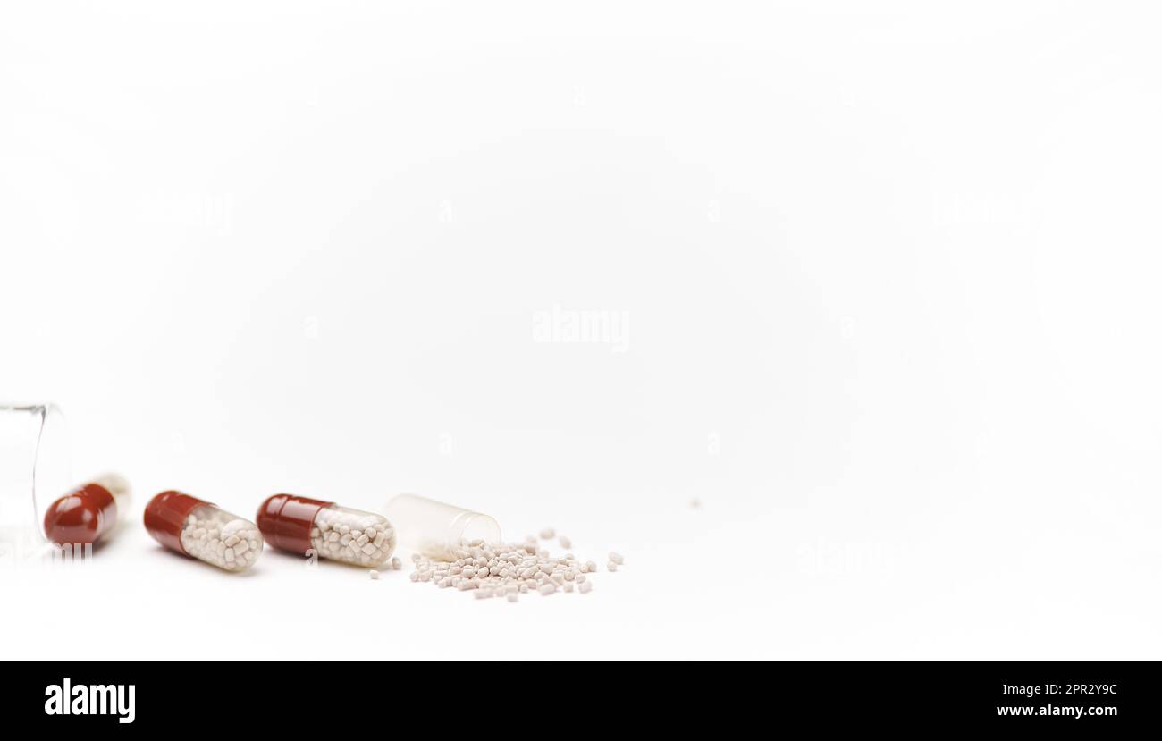 Still life with enteric capsules spilling out from gel translucent ...