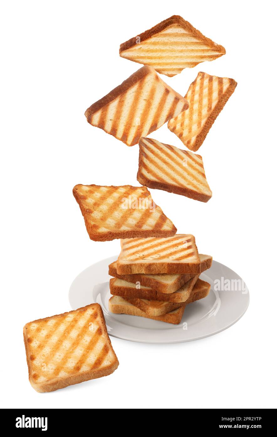 Delicious toasted bread falling into plate on white background Stock ...