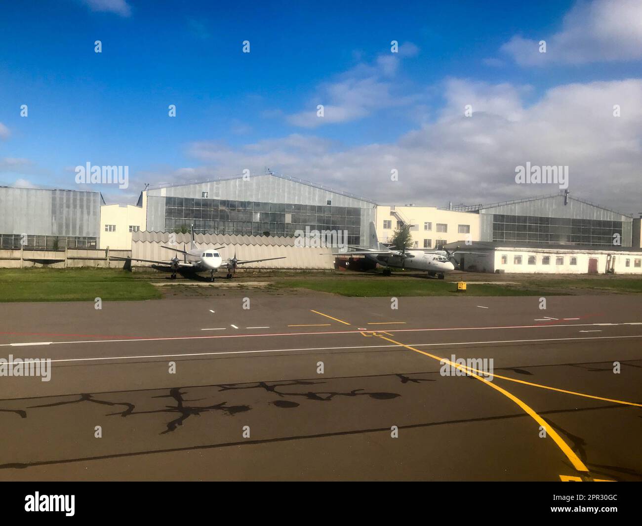 Two big white powerful fast planes are parked near the aircraft hangars ...