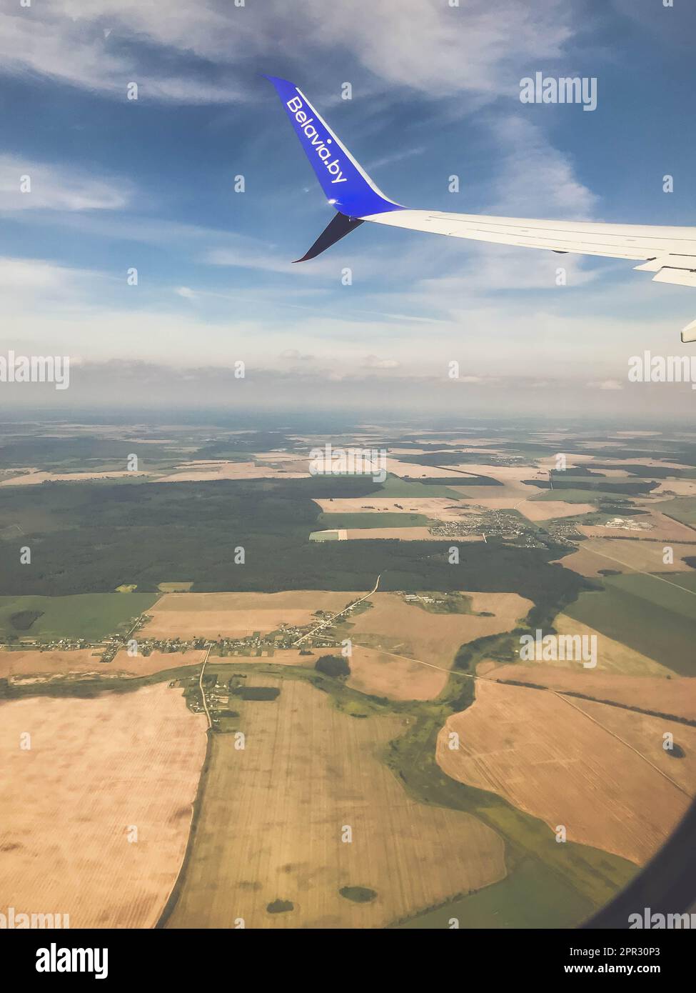 the plane flies at a great height over an empty field with herbs and ...