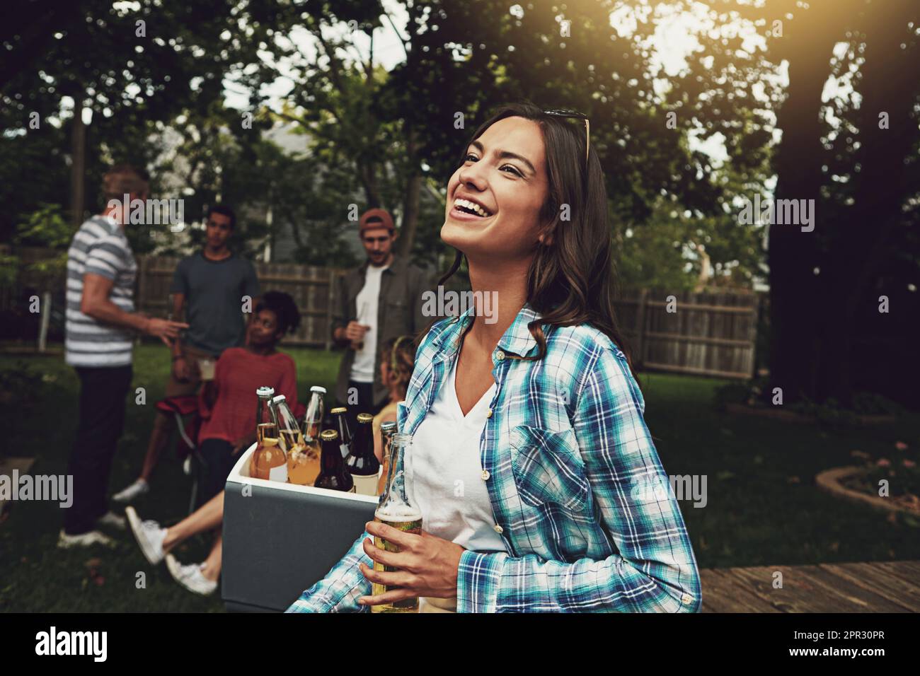 Saying cheers to summer. a young woman enjoying a party with friends ...