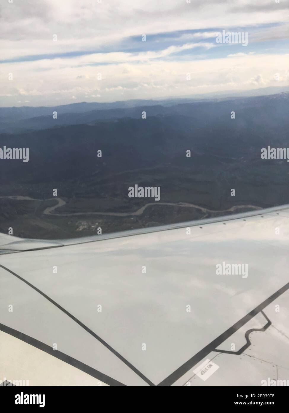 Wing of a beautiful fast jet airplane with an engine in the air at high ...