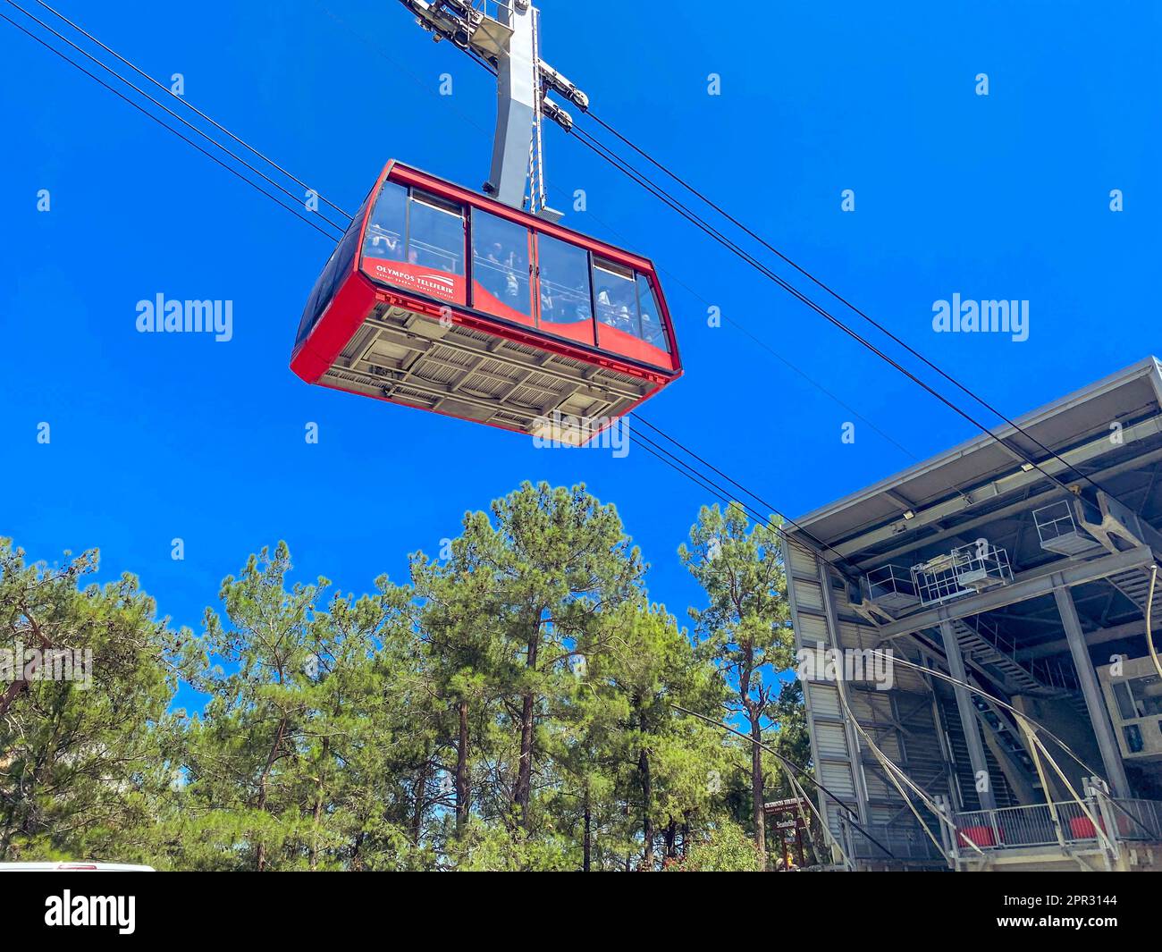 cable car on the mountain. cabin with tourists moves on black, thick ...
