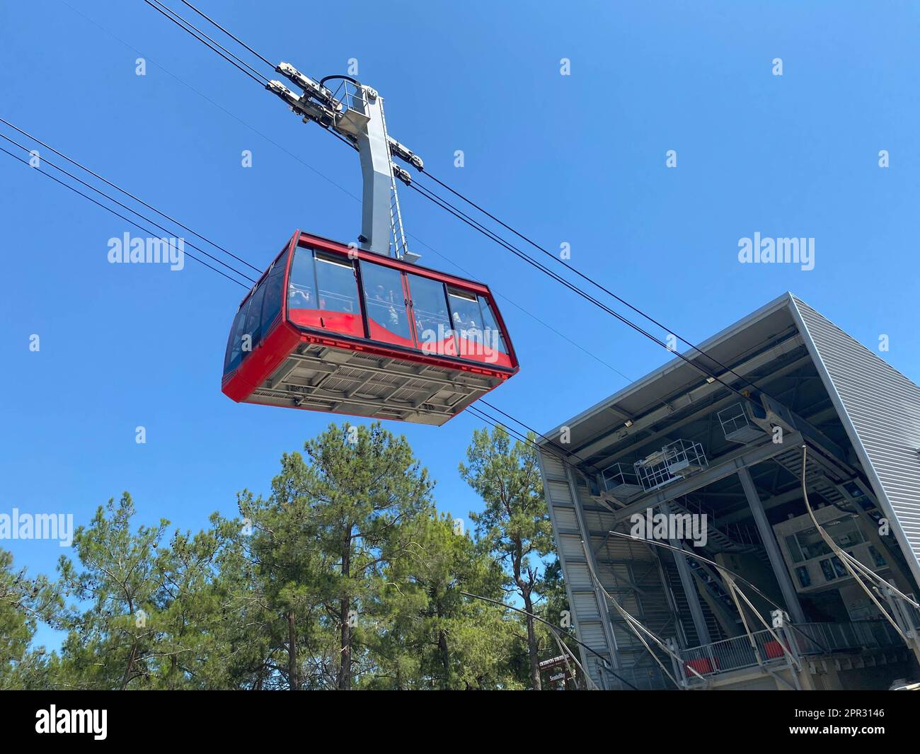 Red modern tourist cabin of the cable car ascends the mountains against ...