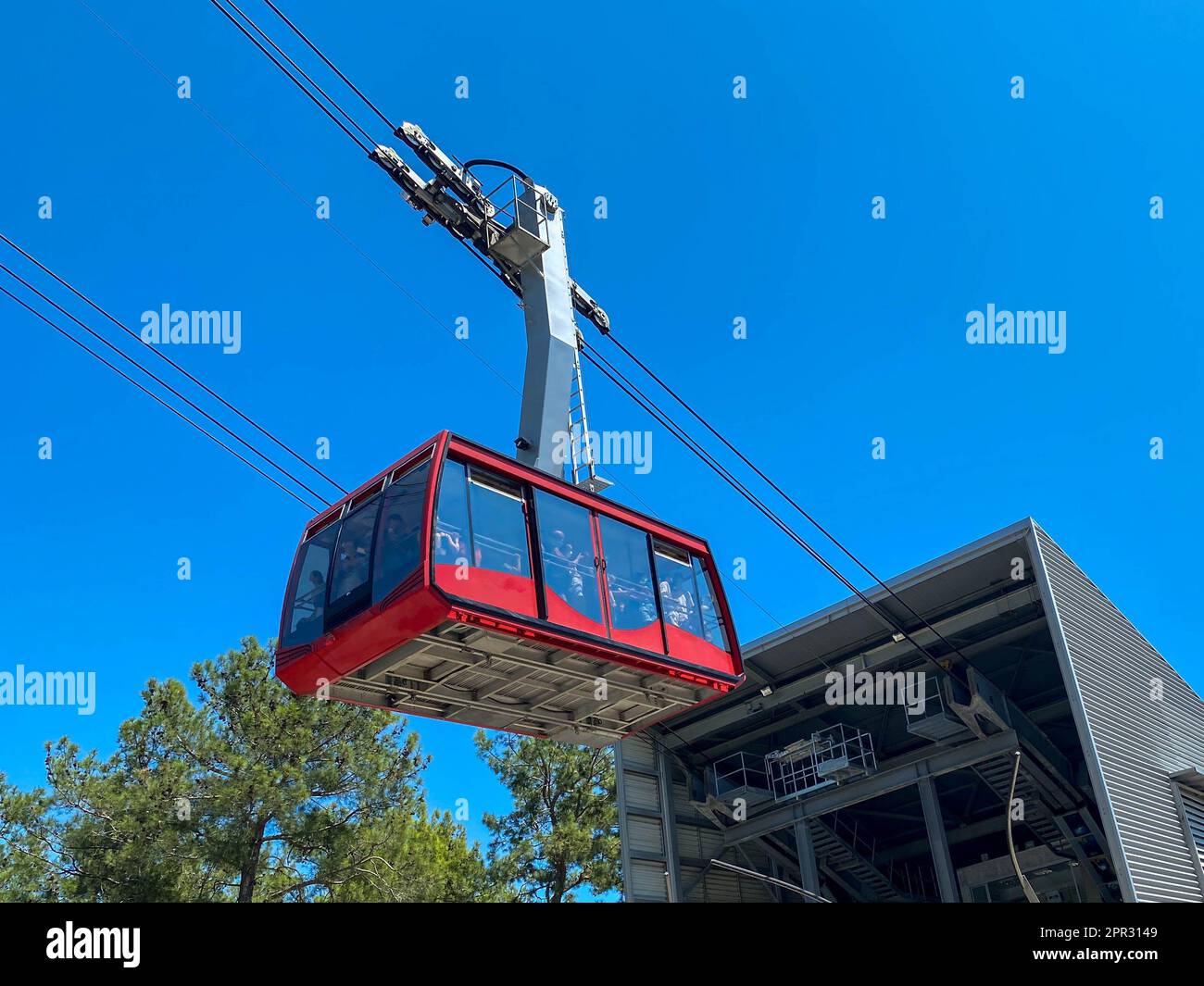 Red modern tourist cabin of the cable car ascends the mountains against ...