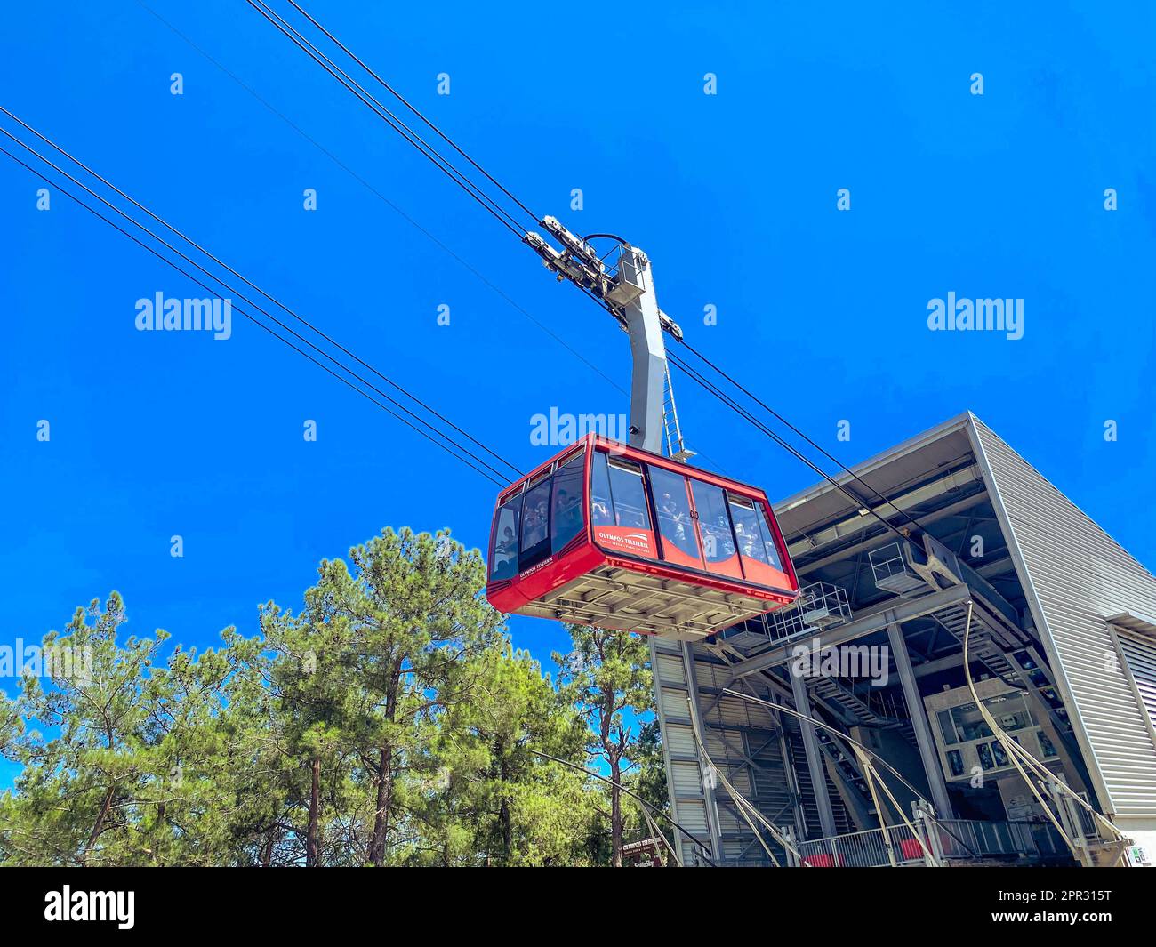 cable car on the mountain. cabin with tourists moves on black, thick ...