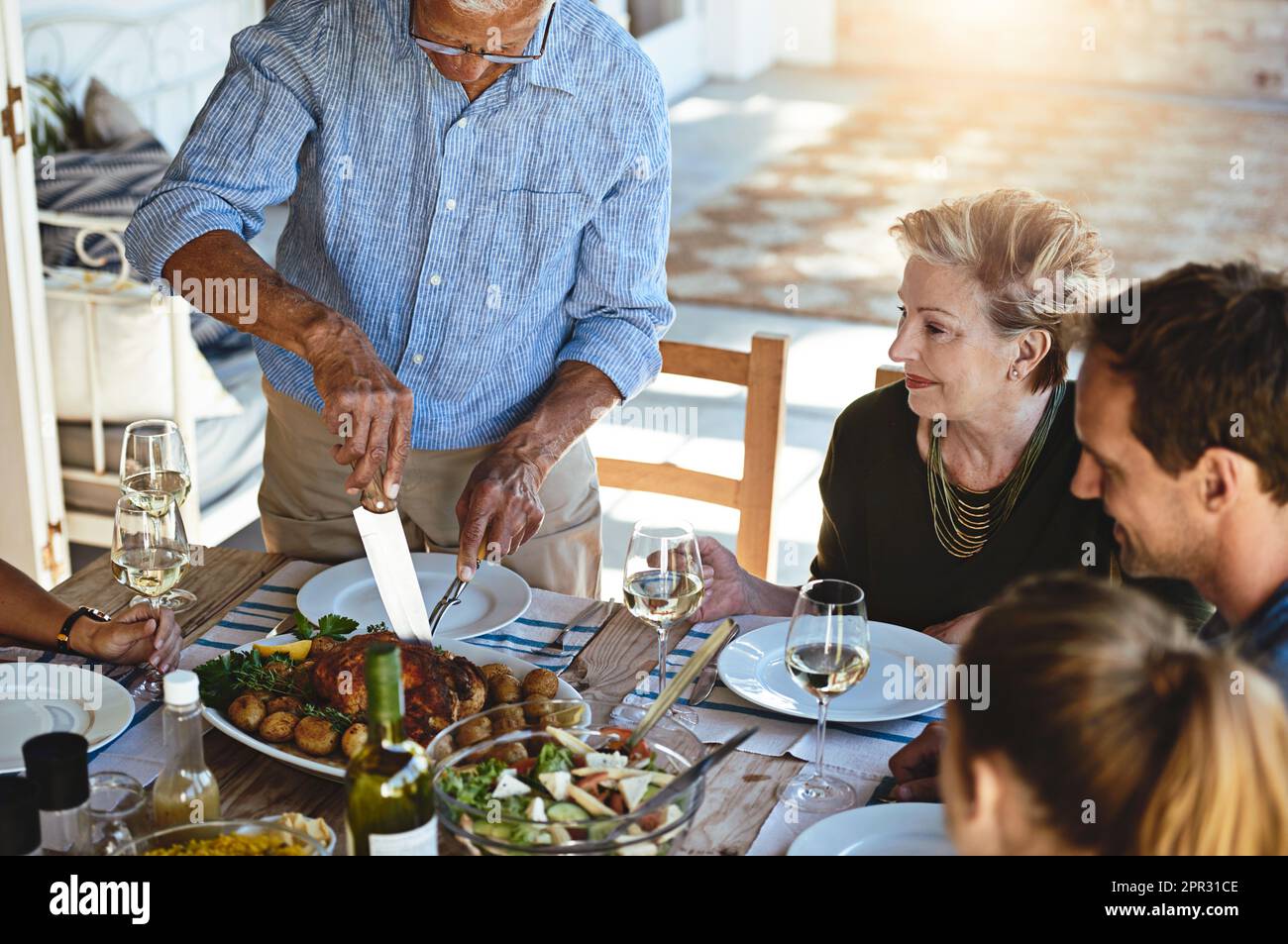 Laid-back luncheons with family. a mature man carving a roast while ...
