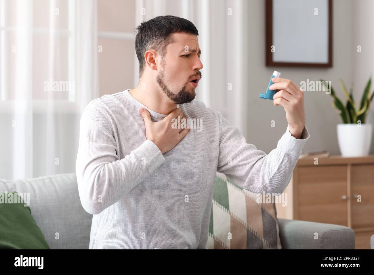 Sick man with inhaler at home Stock Photo - Alamy