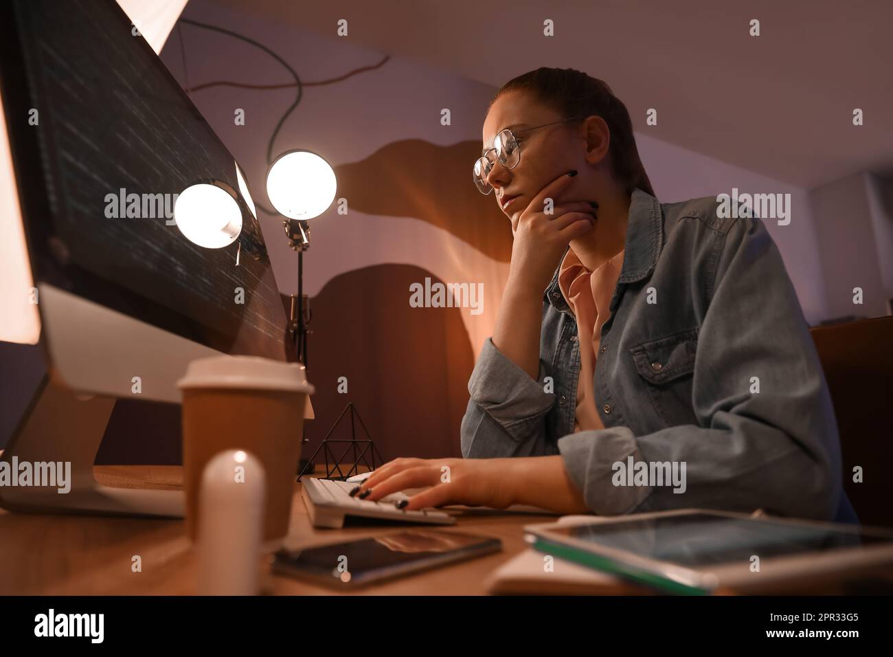 Female programmer working with computer in office at night Stock Photo ...