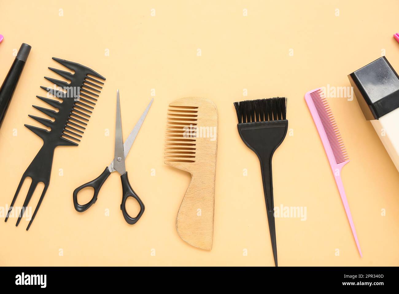 Hair brushes with scissors on beige background Stock Photo - Alamy