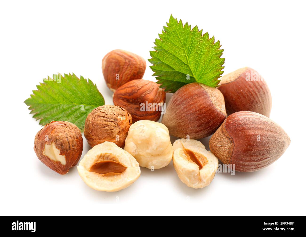 Shelled hazelnuts with leaves on white background Stock Photo - Alamy
