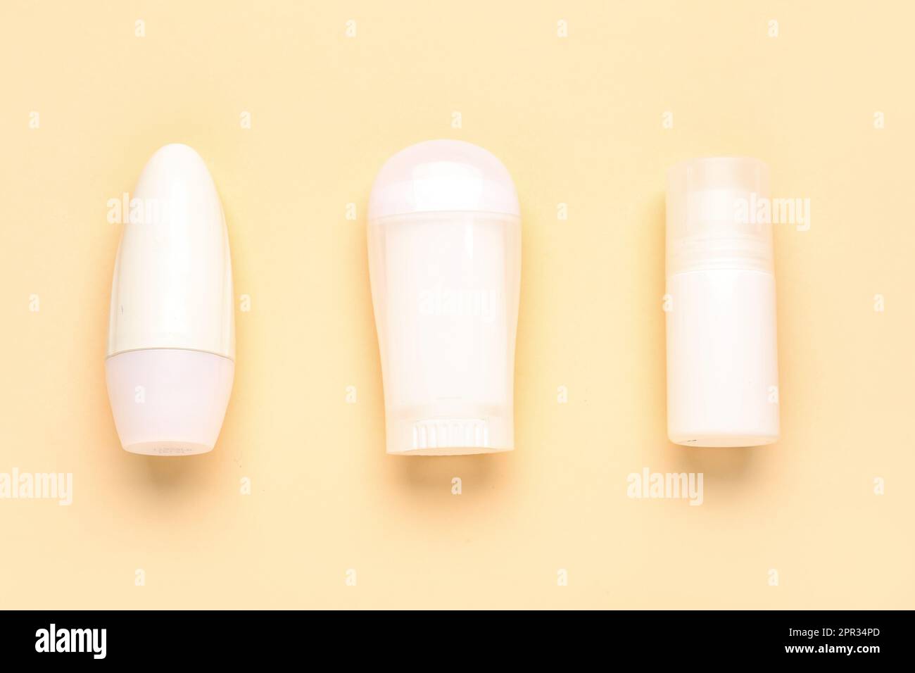 Different deodorant bottles on yellow background Stock Photo - Alamy