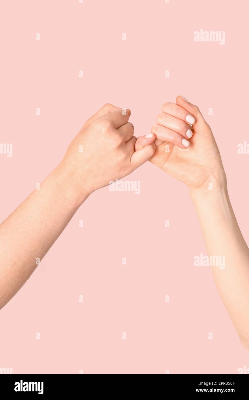 Hands of friends making pinky promise on color background Stock Photo ...