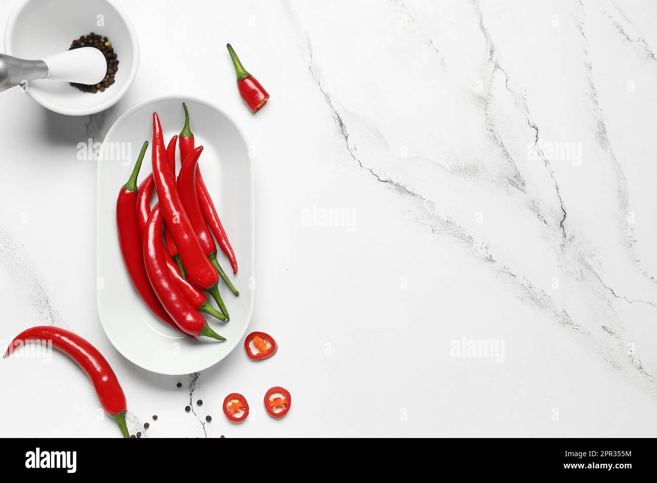 Plate with fresh chili peppers on white marble background Stock Photo ...