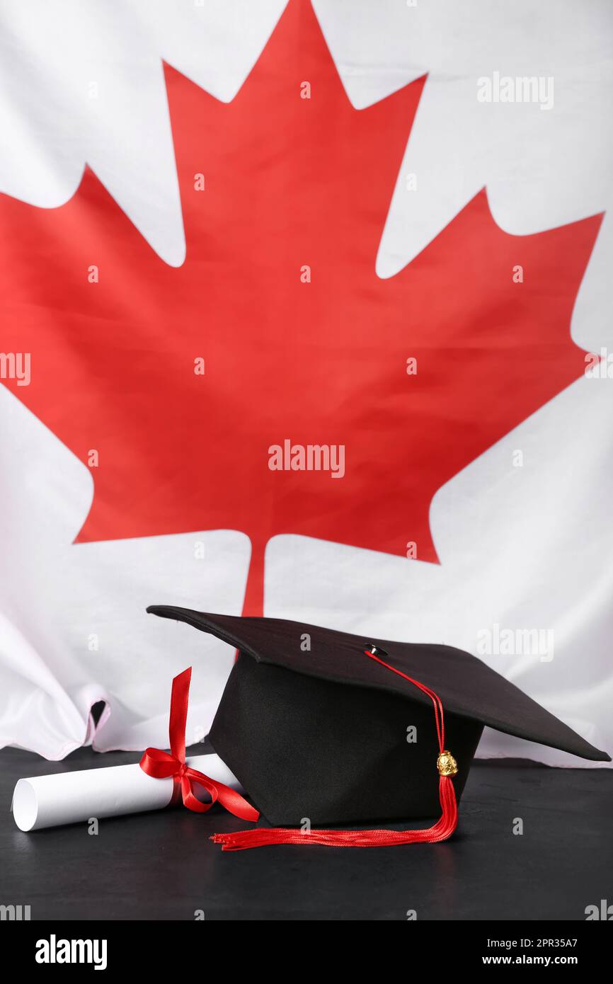 Graduation hat with diploma on table against flag of Canada Stock Photo ...