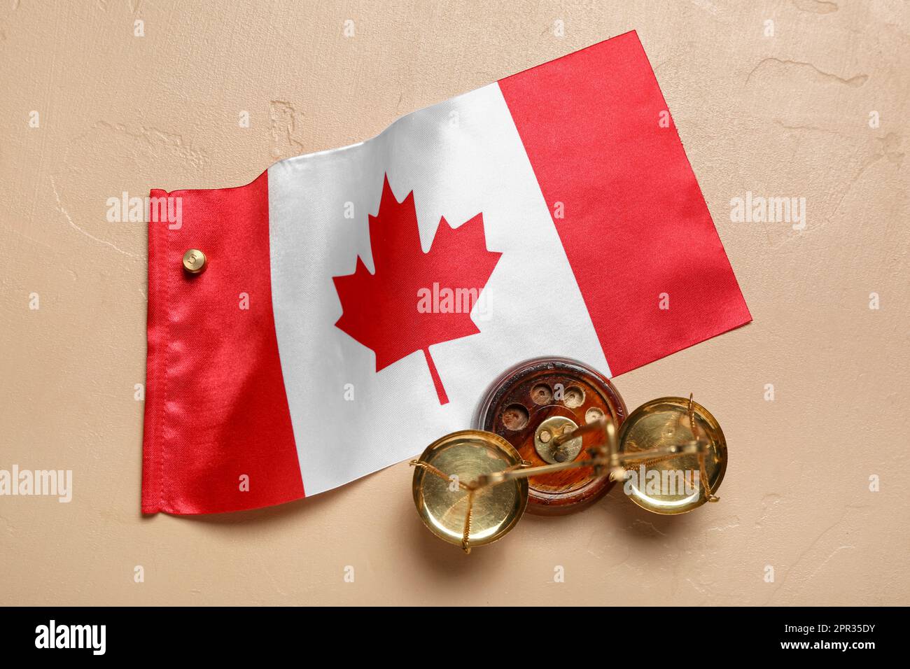 Flag of Canada with justice scales on beige background Stock Photo - Alamy