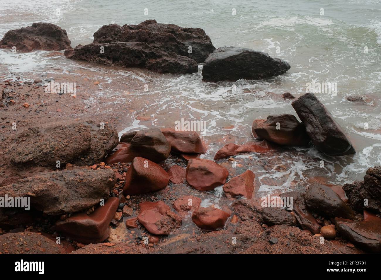 Close-up of red sand, stones, and rocks in Legzira Beach. Rugged ...
