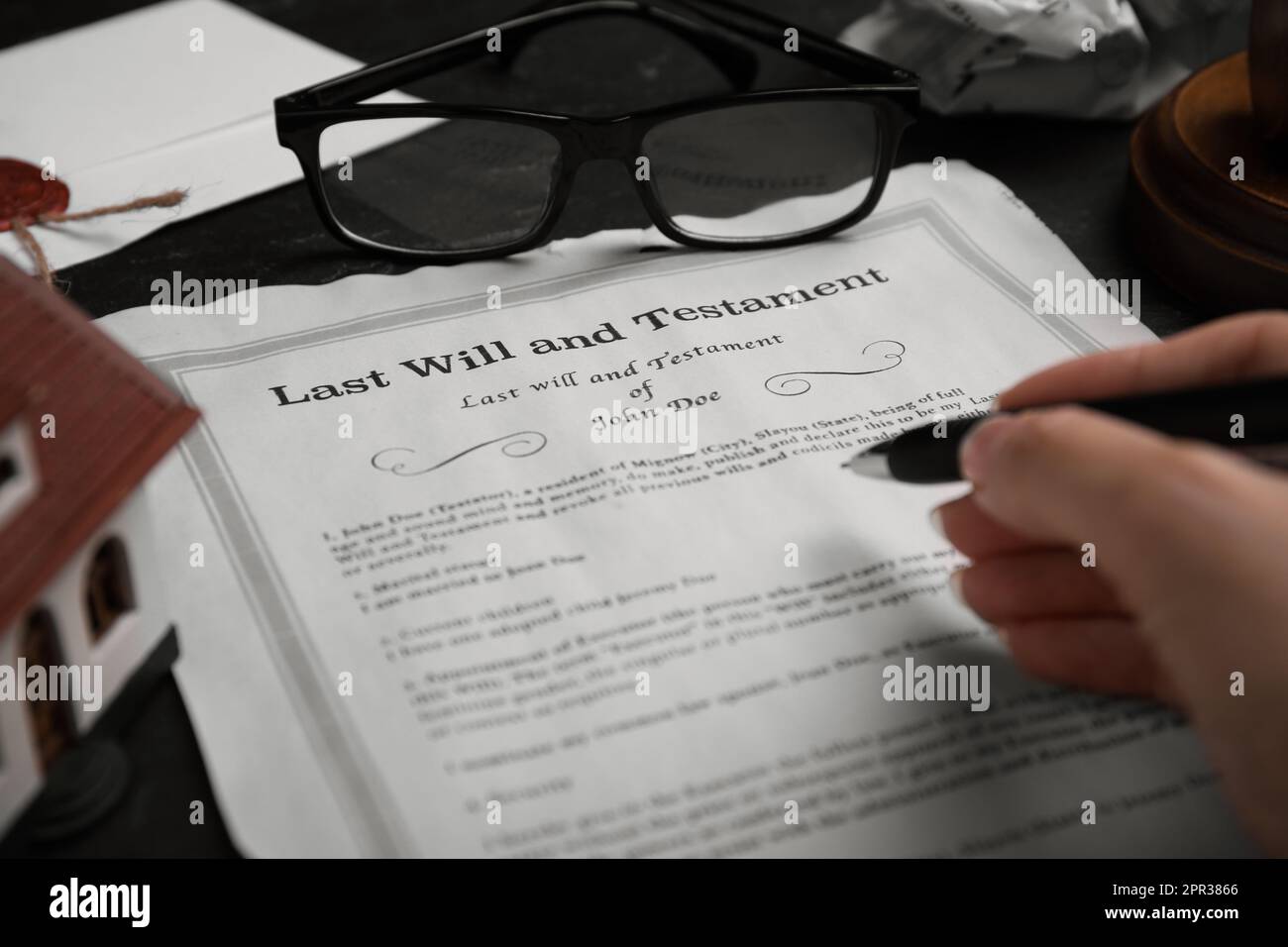 Woman signing last will and testament at black table, closeup Stock ...