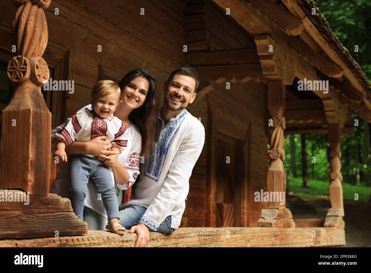 Happy family in Ukrainian national clothes on wooden terrace Stock ...