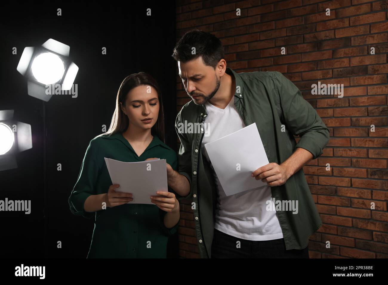 Professional actors reading their scripts during rehearsal in theatre ...