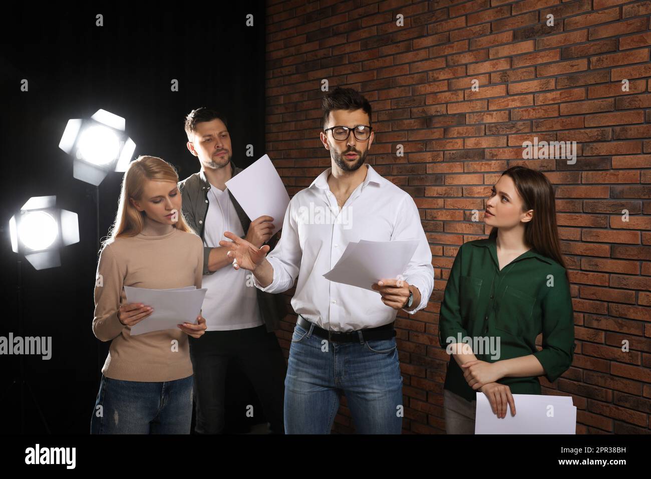 Professional actors reading their scripts during rehearsal in theatre ...
