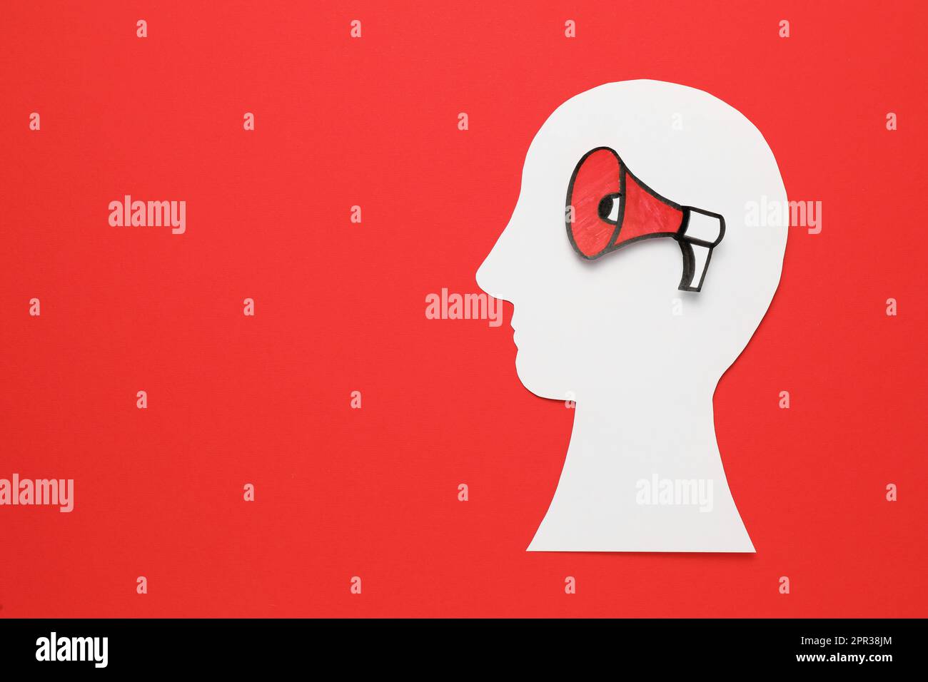 Top view of paper human head cutout with megaphone on red background ...