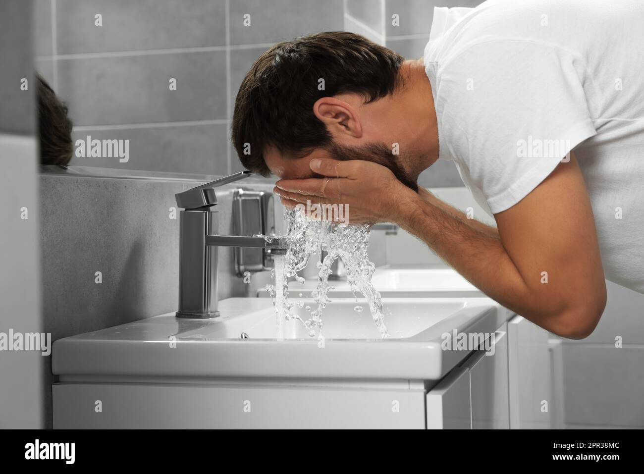Handsome man washing face in bathroom, closeup Stock Photo - Alamy