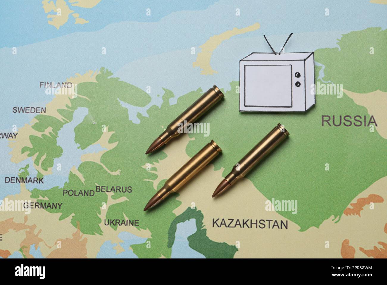 Paper TV and bullets on world map, flat lay. Hybrid warfare concept ...