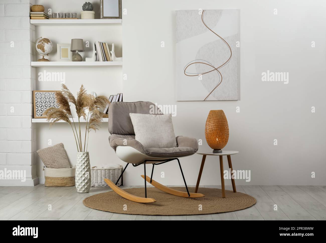 Soft rocking chair with pillow on rug near wall in room. Interior ...