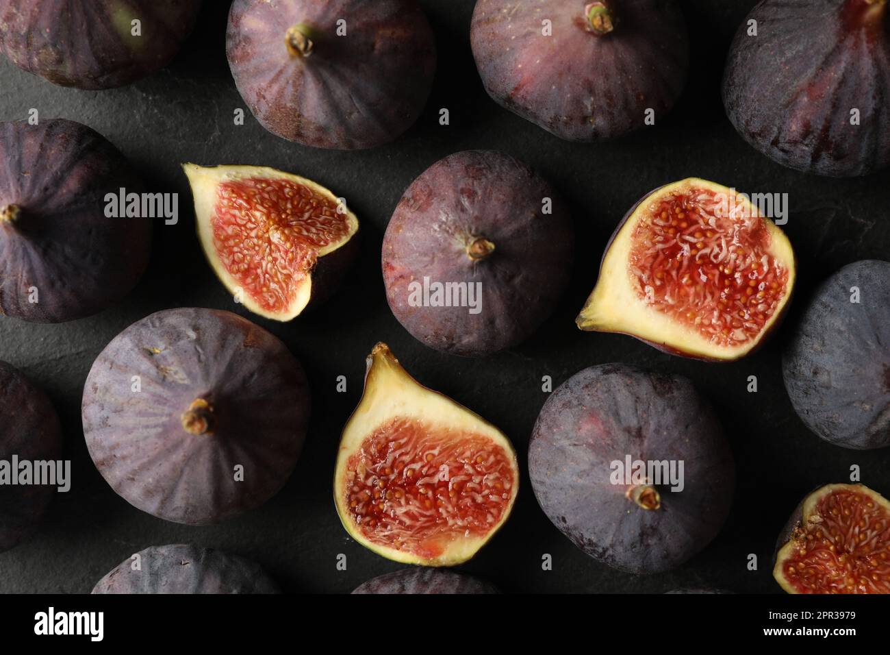 Tasty cut and whole figs on black table, flat lay Stock Photo - Alamy