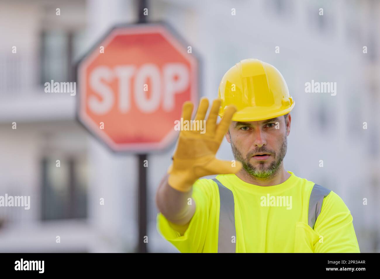 Serious worker with stop road sign. Builder with stop gesture, no hand ...