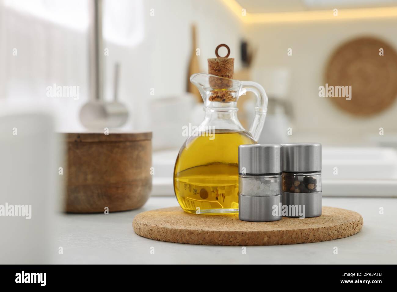 Salt and pepper mills with bottle of oil on table in kitchen Stock ...