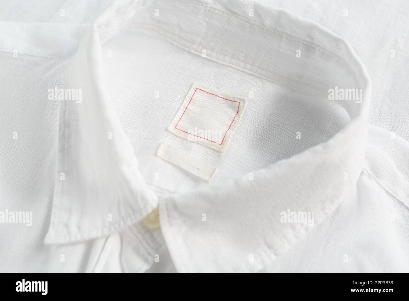 Blank clothing labels on white shirt, closeup Stock Photo - Alamy