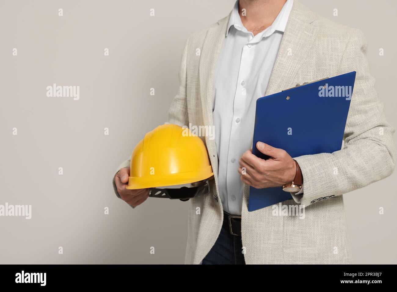 Professional engineer with hard hat and clipboard on white background ...