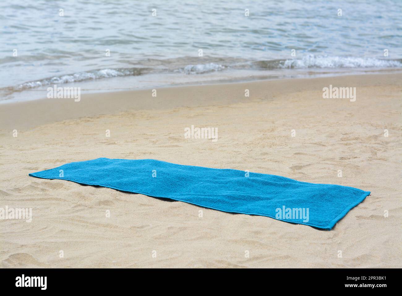 Blue towel on sandy beach near sea Stock Photo - Alamy
