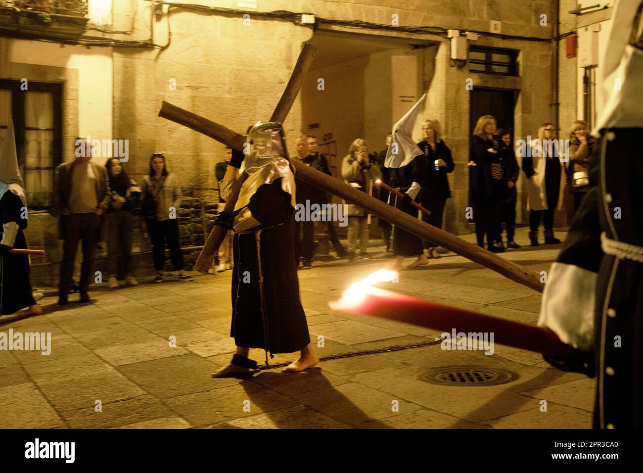 Penitents hide their identity with hoods, as they process with crosses ...