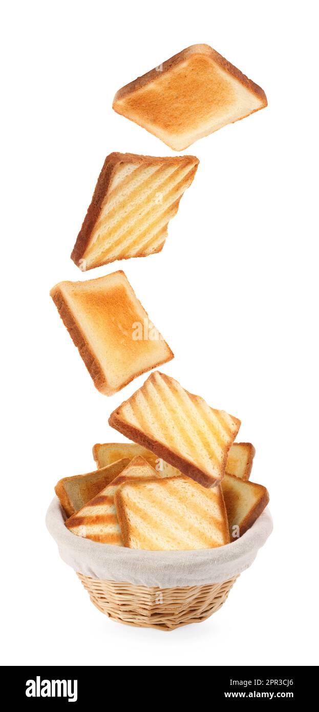 Delicious toasted bread falling into basket on white background Stock ...