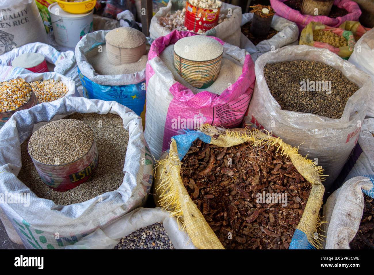 rice and beans in sacks with measuring tins for sale in the market in ...