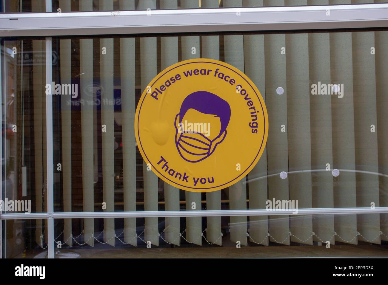 round window sign for Please wear face coverings - thank you in purple ...